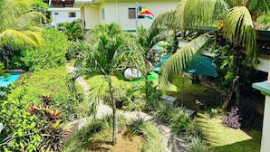 Um resort tropical com piscina, vegetação exuberante e uma bandeira.