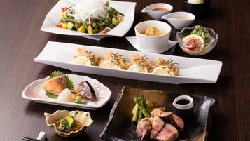 Diversos pratos japoneses, incluindo sashimi, legumes e um fondue.