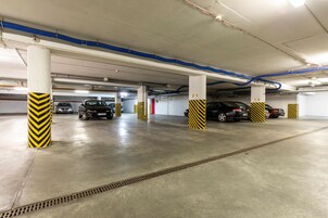 Um parque de estacionamento com vários níveis, com pisos e pilares de betão marcados com sinalização em amarelo e preto.