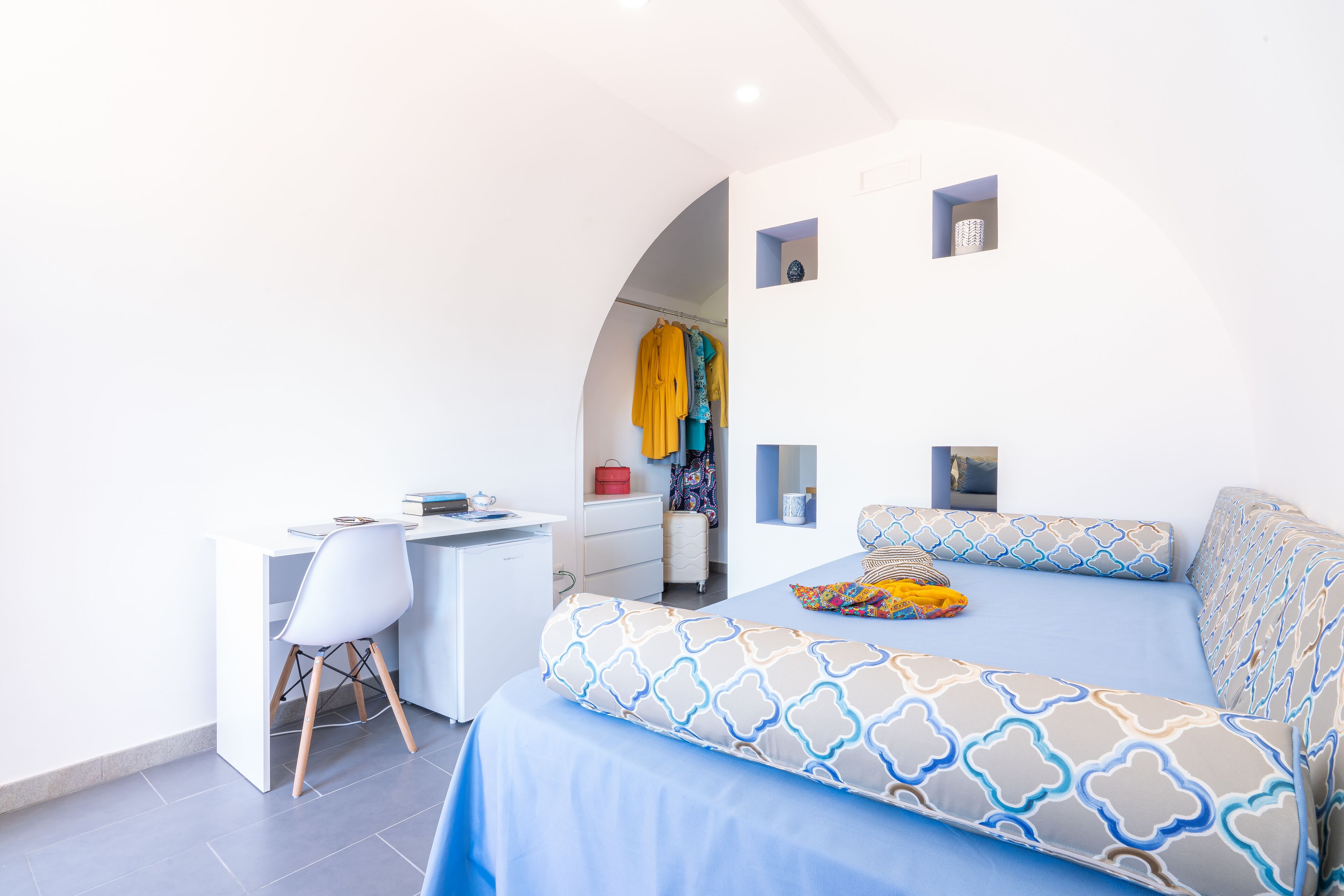 Quarto moderno com cama, escrivaninha e cadeira.