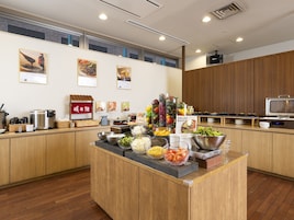 Disposição de buffet com diversos alimentos e um micro-ondas.