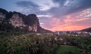 Paisagem costeira com um penhasco imponente e uma fileira de edifícios modernos ao fundo.