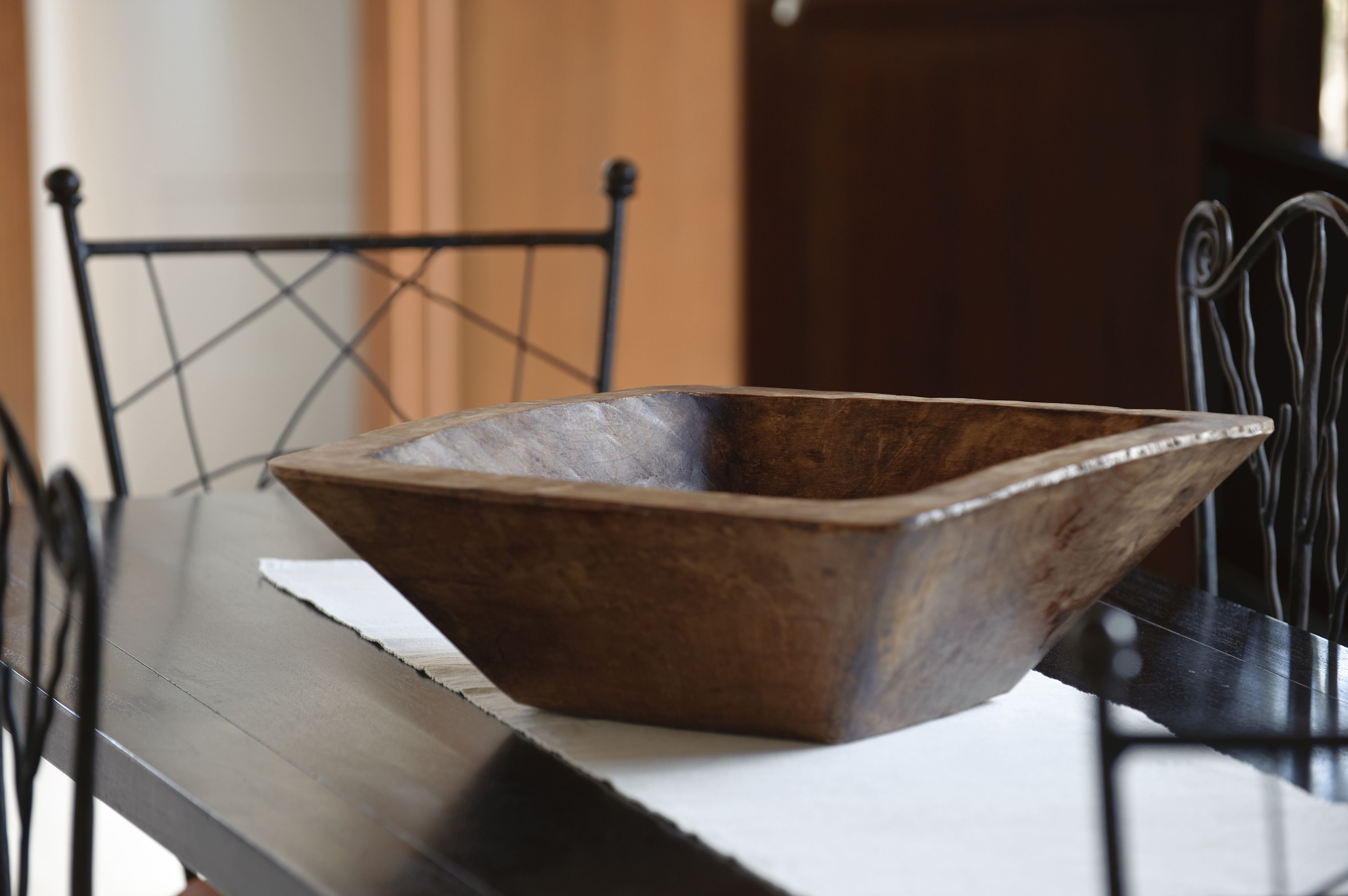 Uma tigela de madeira sobre uma mesa escura de madeira.