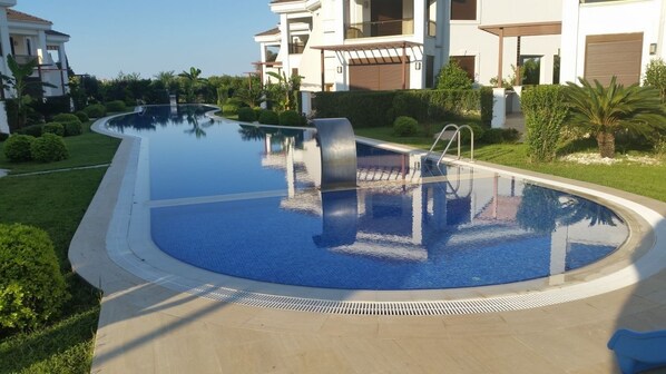 Piscina externa, guarda-sóis, espreguiçadeiras