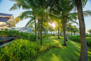 Um resort com palmeiras, piscina e edifícios modernos.