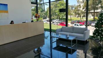 Uma área de recepção com balcão, um sofá e uma mesa de centro.