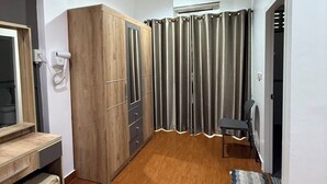 Quarto com guarda-roupa de madeira, espelho, cadeira e tapete.