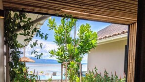 Uma varanda com vista para o mar, uma mesa pequena e uma cadeira.