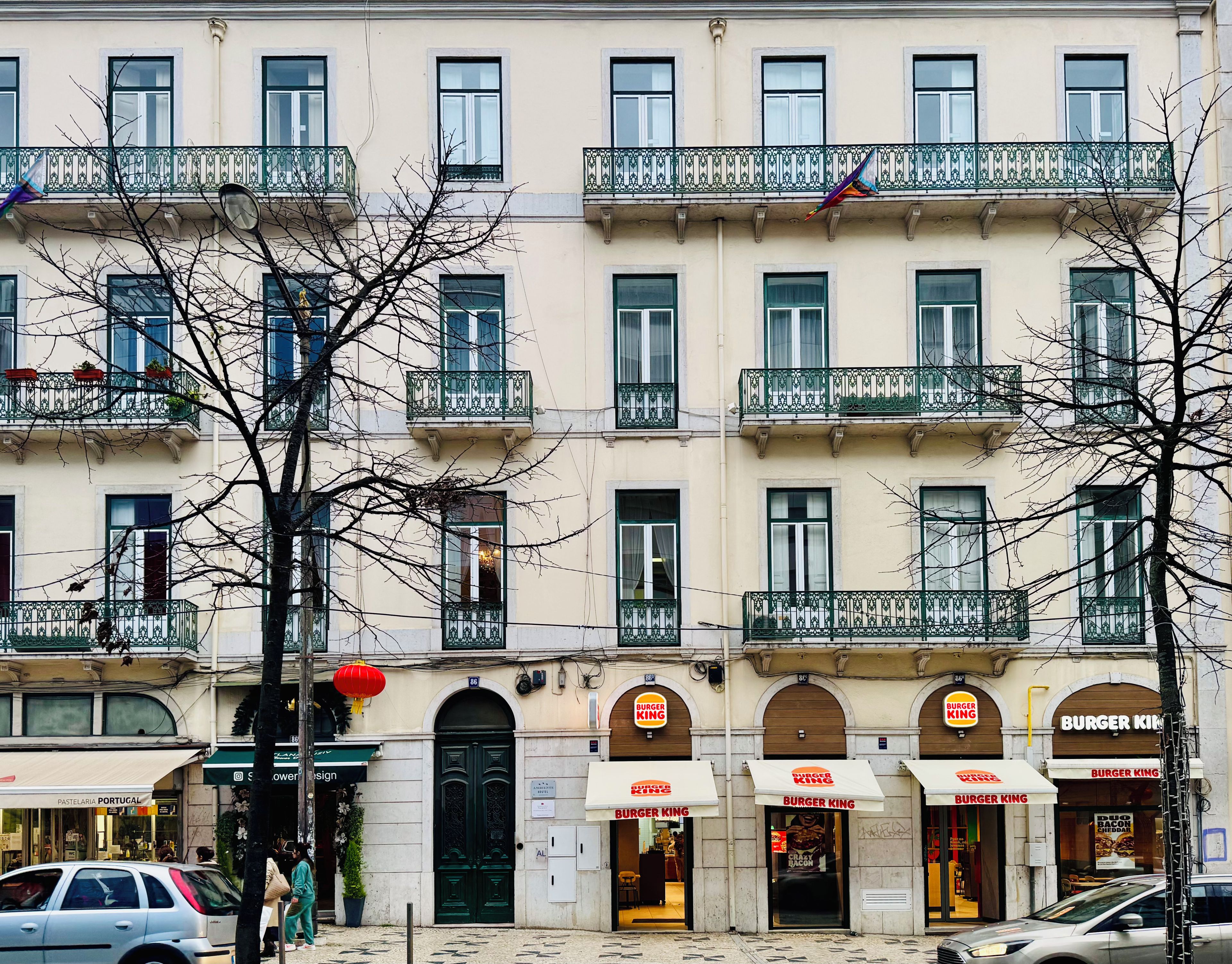 Um edifício com vários andares e uma fileira de restaurantes Burger King no andar térreo.