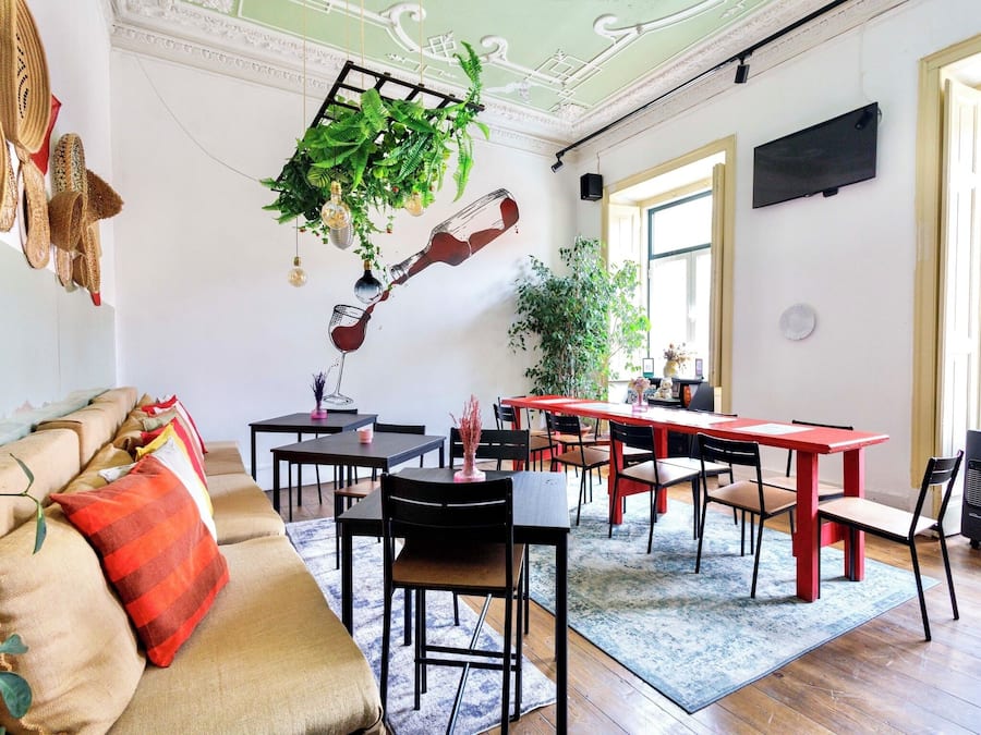 Uma sala de estar moderna com sofá, mesa de jantar, cadeiras e uma planta pendente.