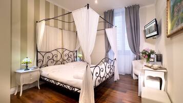 Quarto com cama de dossel, mesas de cabeceira, escrivaninha e uma cadeira.