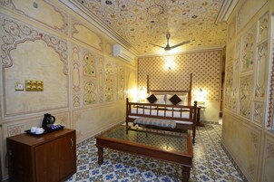 Quarto tradicional com cama, um armário de madeira e ventilador de teto.