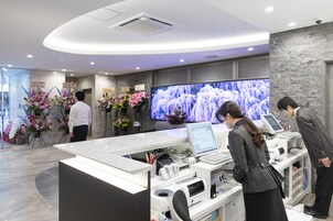 Uma área de recepção com balcão de mármore, uma televisão de tela plana grande e design de interiores moderno.