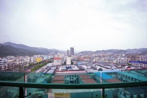 Paisagem urbana com edifícios e uma cordilheira ao fundo.