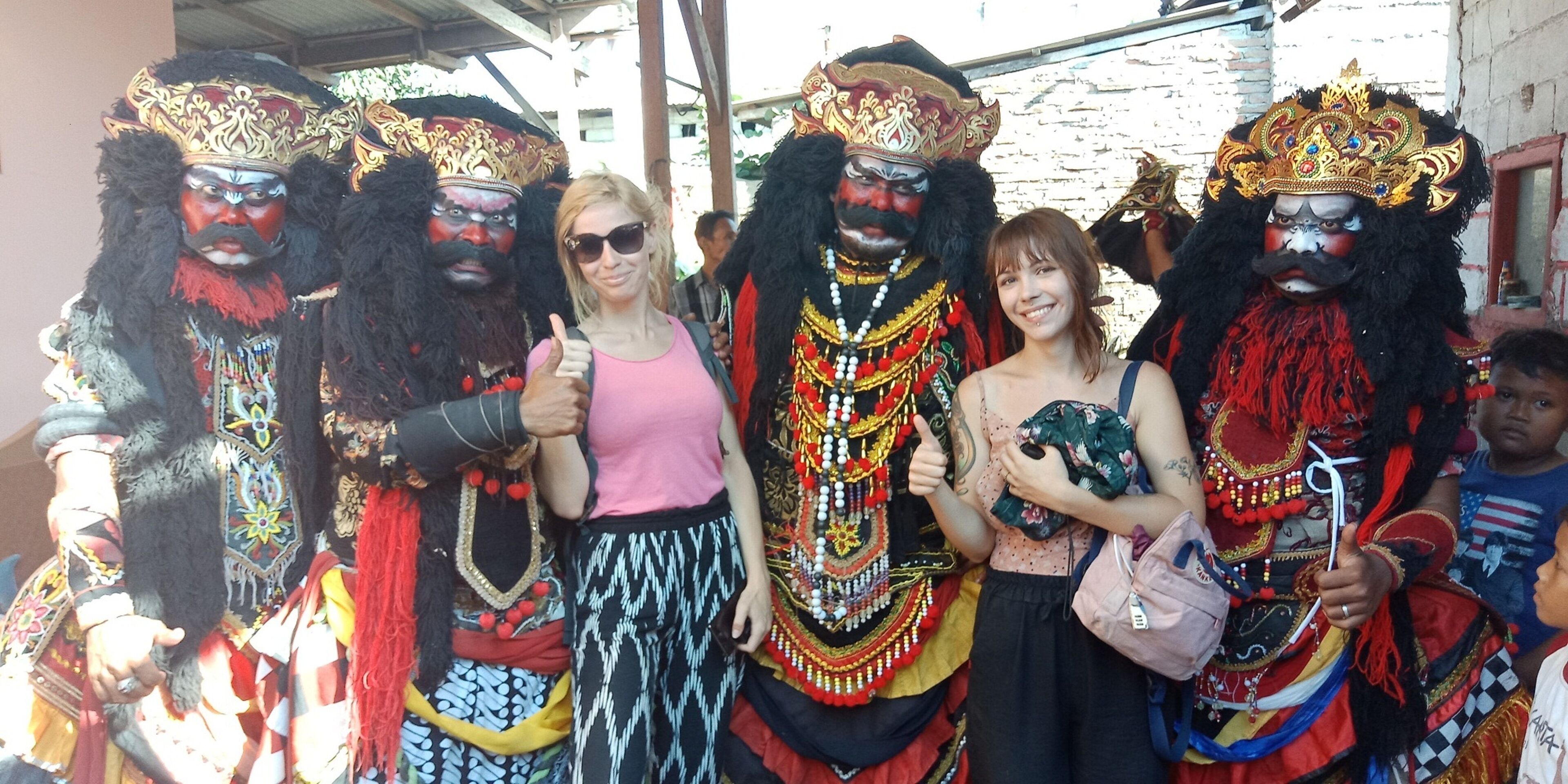 Um grupo de pessoas em trajes típicos, com adereços e ornamentos elaborados.