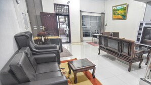 Uma sala de estar com sofá, mesa de centro e rack para televisão.