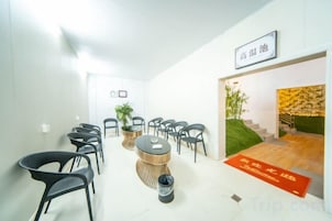 Uma sala de conferências com quadro branco, cadeiras pretas e uma mesa redonda.