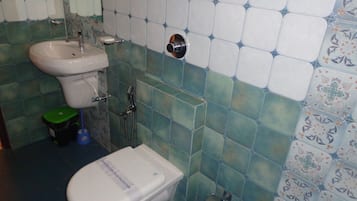 Uma casa de banho com sanita, bidé e lavatório.