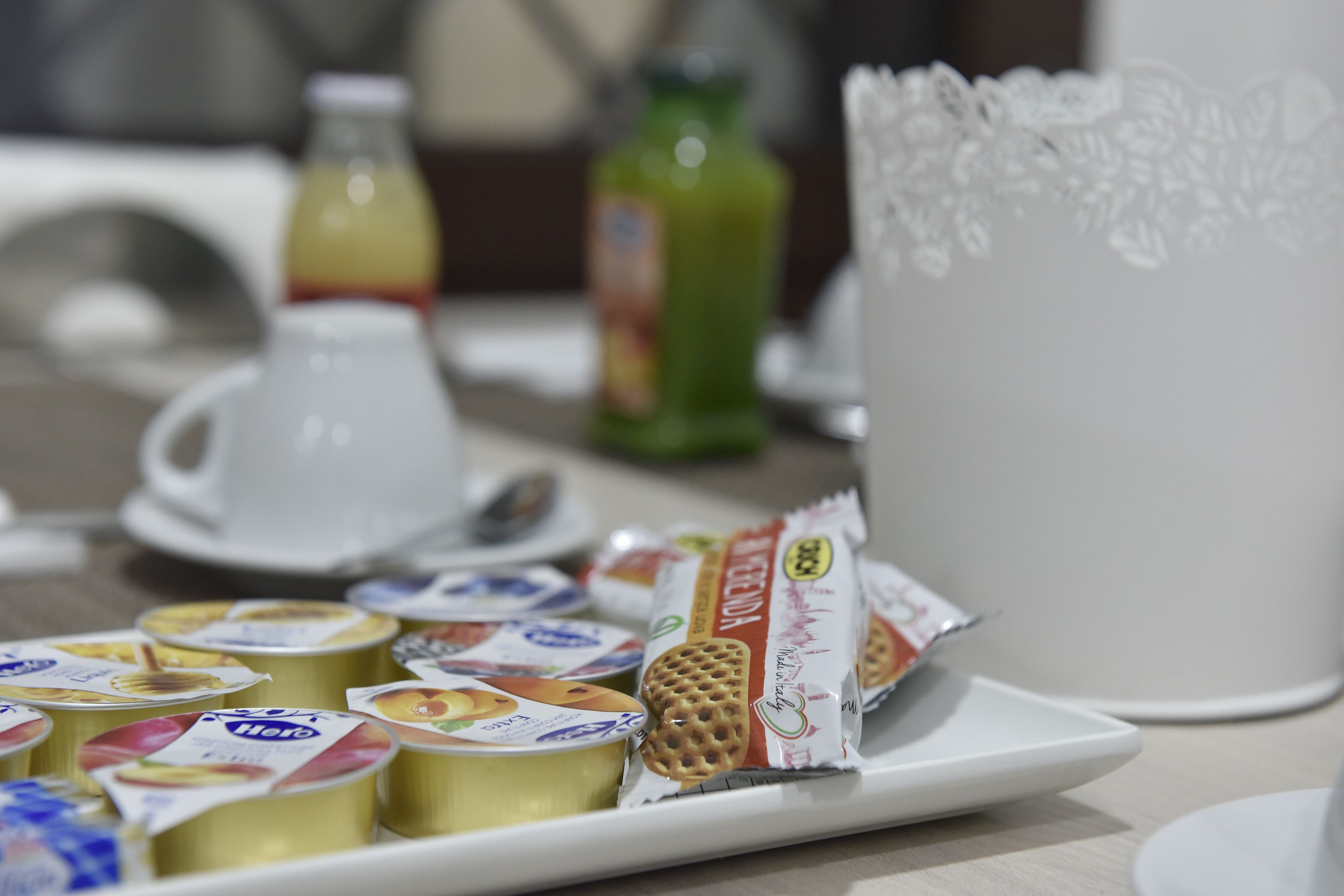 Uma bandeja com alimentos embalados e uma caneca de cerâmica branca sobre uma mesa.