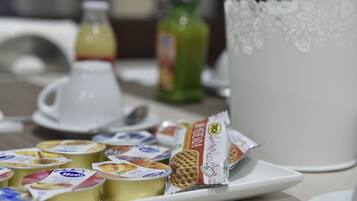 Uma bandeja com alimentos embalados e uma caneca de cerâmica branca sobre uma mesa.