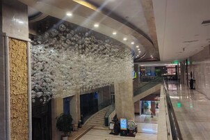 Um espaço amplo e interno, com teto curvo, escada e uma instalação de luz decorativa.