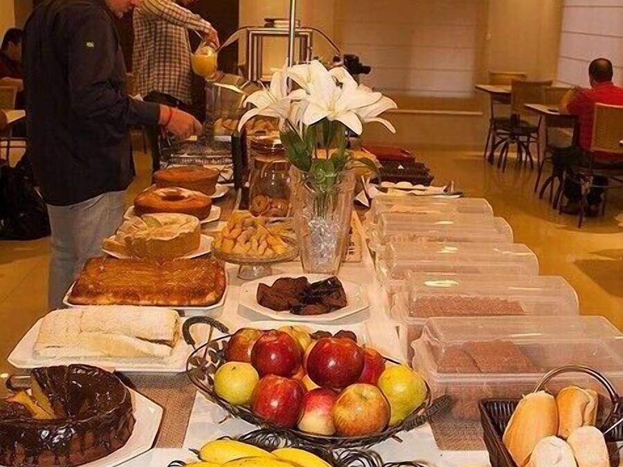 Buffet com diversos pratos e um vaso de flores.