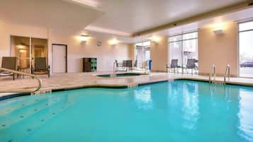 Piscina com várias pistas de natação, vestiário e área de estar com cadeiras.