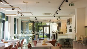 Um interior de restaurante moderno com mesas, cadeiras e um bar, com vista para o exterior.