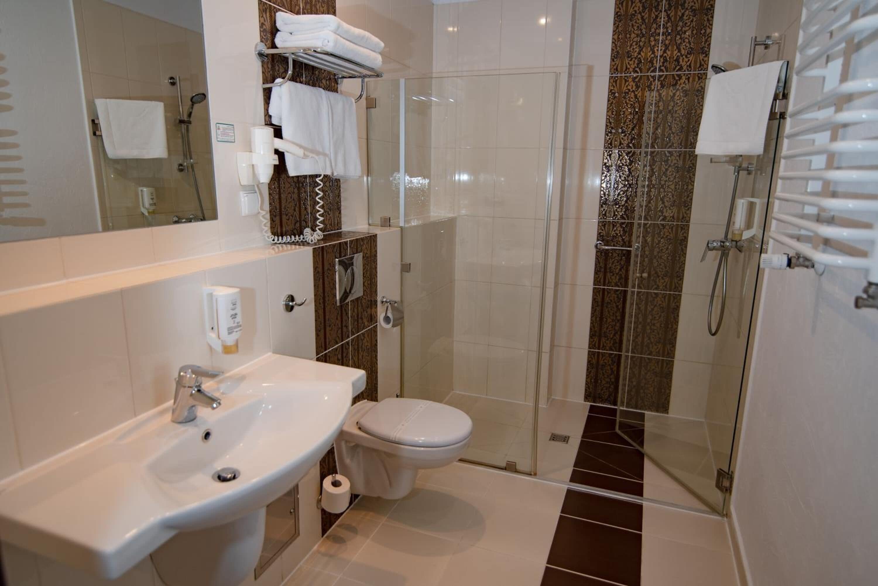Uma casa de banho moderna com lavatório, sanita e cabine de duche em vidro.