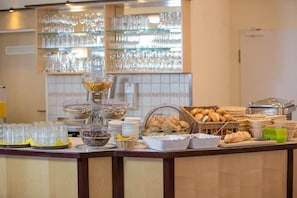 Um balcão de buffet com diversos alimentos e peças de vidro.