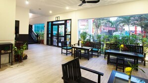 Amplo espaço interno com piso de madeira, ventilador de teto e uma grande janela com vista para o exterior.