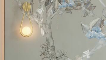 Paredes com um desenho floral em relevo e uma luminária moderna.