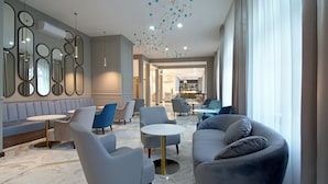 Uma área de estar moderna com assentos, um bar e vista para o bar.