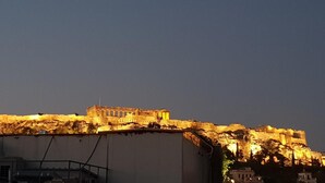 Um edifício histórico com uma entrada imponente e uma estrutura grande e iluminada no topo.