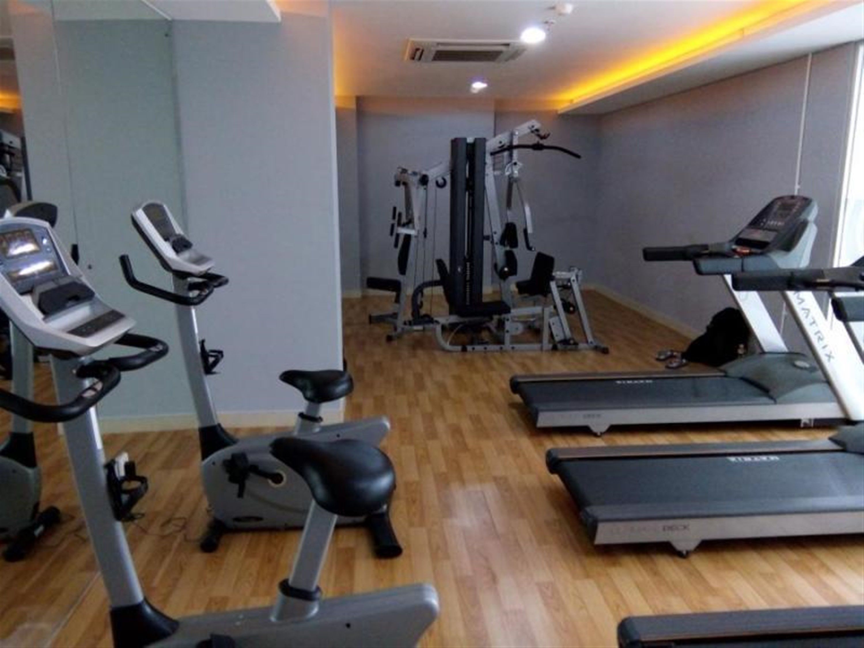 Uma academia com esteiras, elípticos e equipamentos de musculação.
