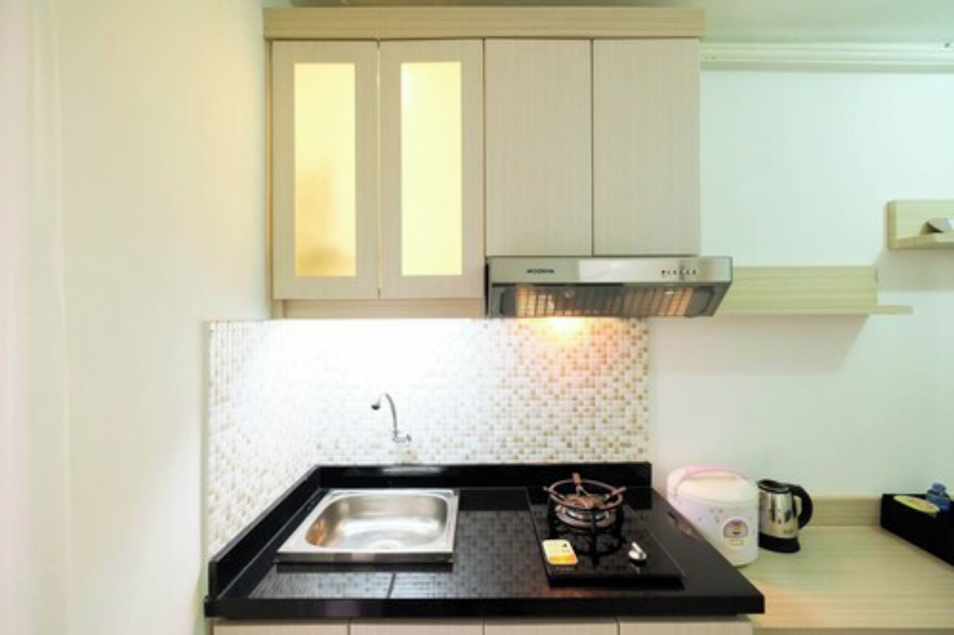Uma cozinha compacta com pia, fogão e micro-ondas.