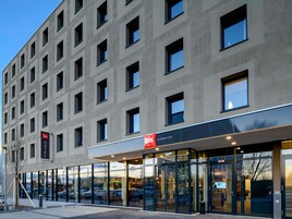 Um moderno edifício de hotel com fachada de vidro, várias janelas e uma placa chamativa com a inscrição 'Landshut City'.