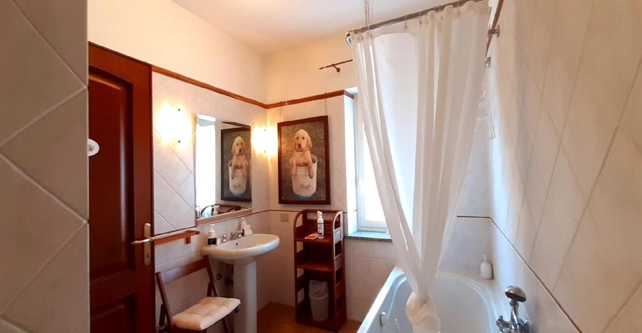 Casa de banho com lavatório, espelho e zona de duche.