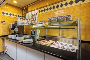 Um balcão de buffet com alimentos e uma estação de café.