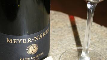 Uma garrafa de vinho Meyer-Näkel, com rolha e uma taça de vinho, sobre uma bancada.