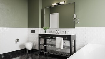 Casa de banho moderna com toucador preto, lavatório branco e um espelho grande.