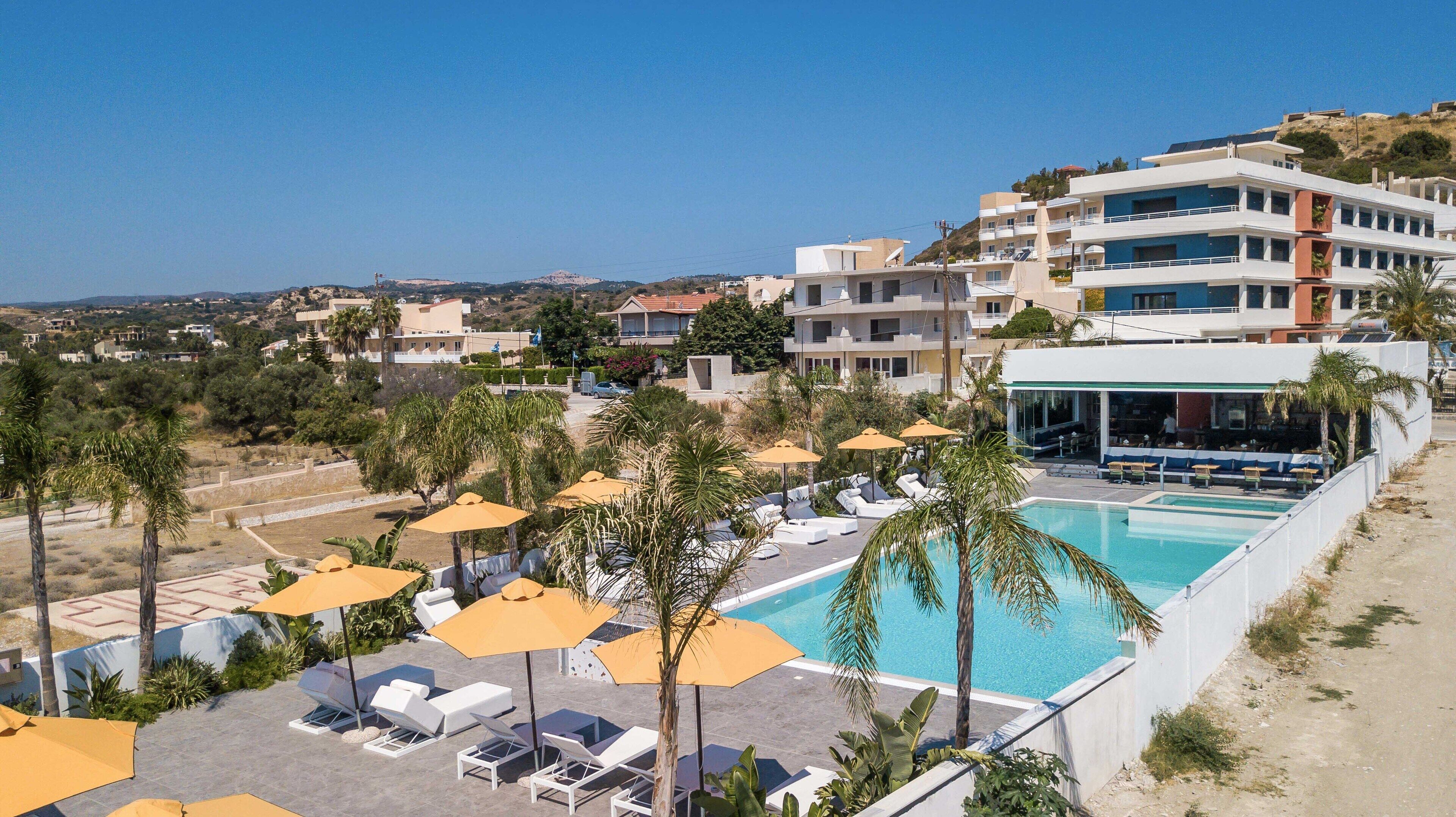 Um resort com piscina, espreguiçadeiras e guarda-sóis.