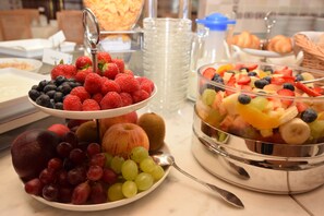 Um buffet com diversas frutas e doces.