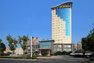 Hotel de vários andares com design moderno, destacando uma fachada em vidro e um telhado plano.