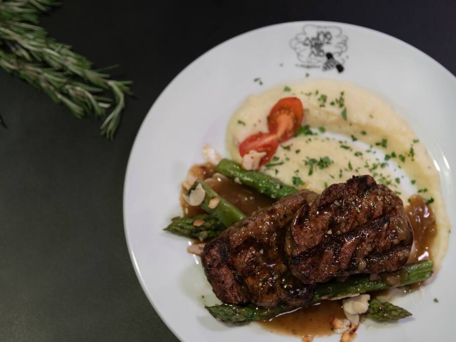 Prato com bife, aspargos e purê de batatas.