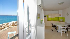 Quarto com vista para o mar, área de refeições e cozinha compacta.