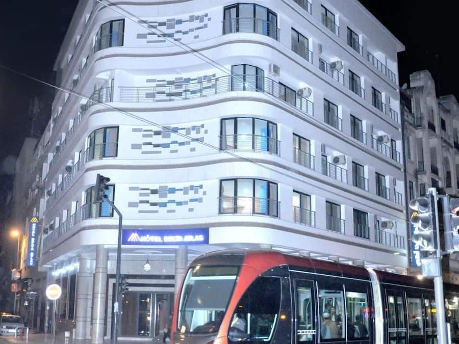 Um hotel moderno com fachada curva, várias varandas e uma placa chamativa para HOTEL DELTA ATLAS.