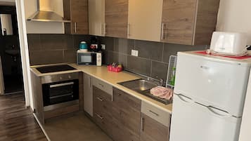 Apartamento luxo, 2 quartos | Cozinha privada | Geladeira, micro-ondas, fogão, cooktop