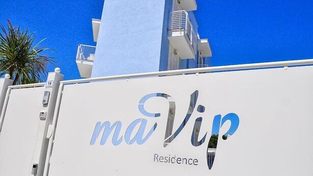 Um edifício branco com a inscrição "ma Vip Residence" em sua lateral.