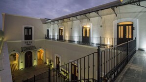 Um hotel com área externa coberta, escadas e várias portas.